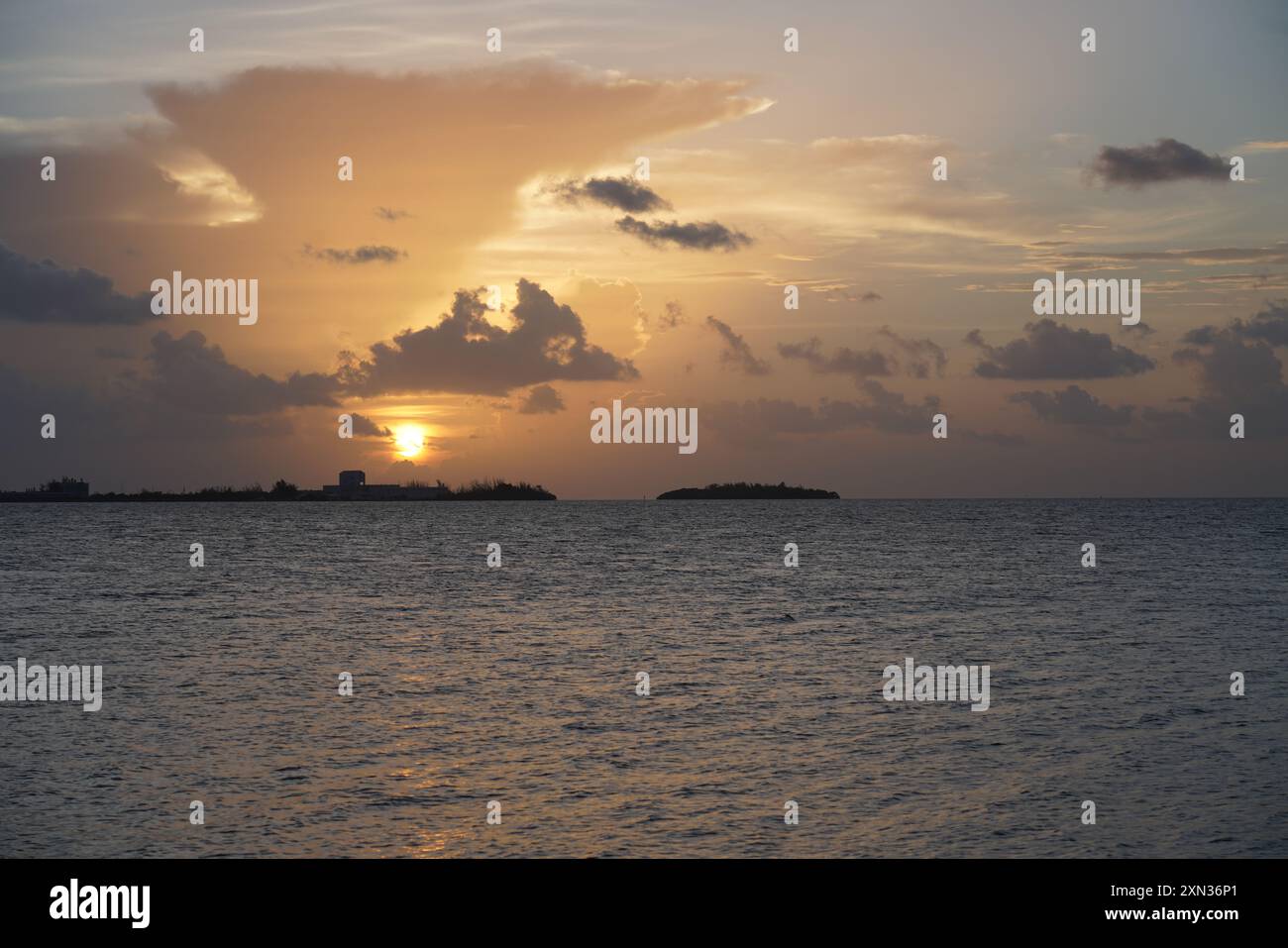 A mesmerizing golden sunset over a tranquil ocean, with distant islands ...
