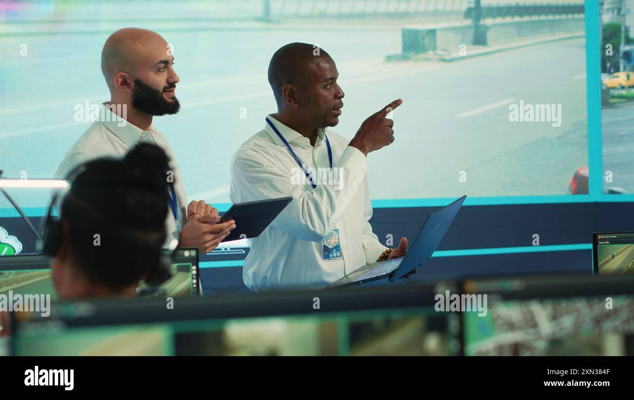 Diverse employees using CCTV surveillance system in monitoring traffic ...