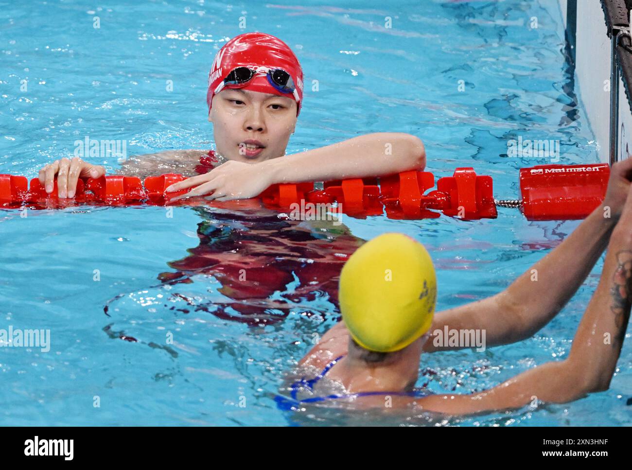 Paris, France. 30th July, 2024. Yang Junxuan (top) of China reacts after the women's 100m ...