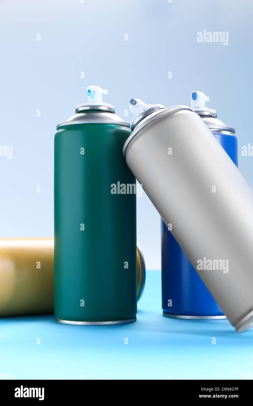 Many spray paint cans on color background Stock Photo - Alamy