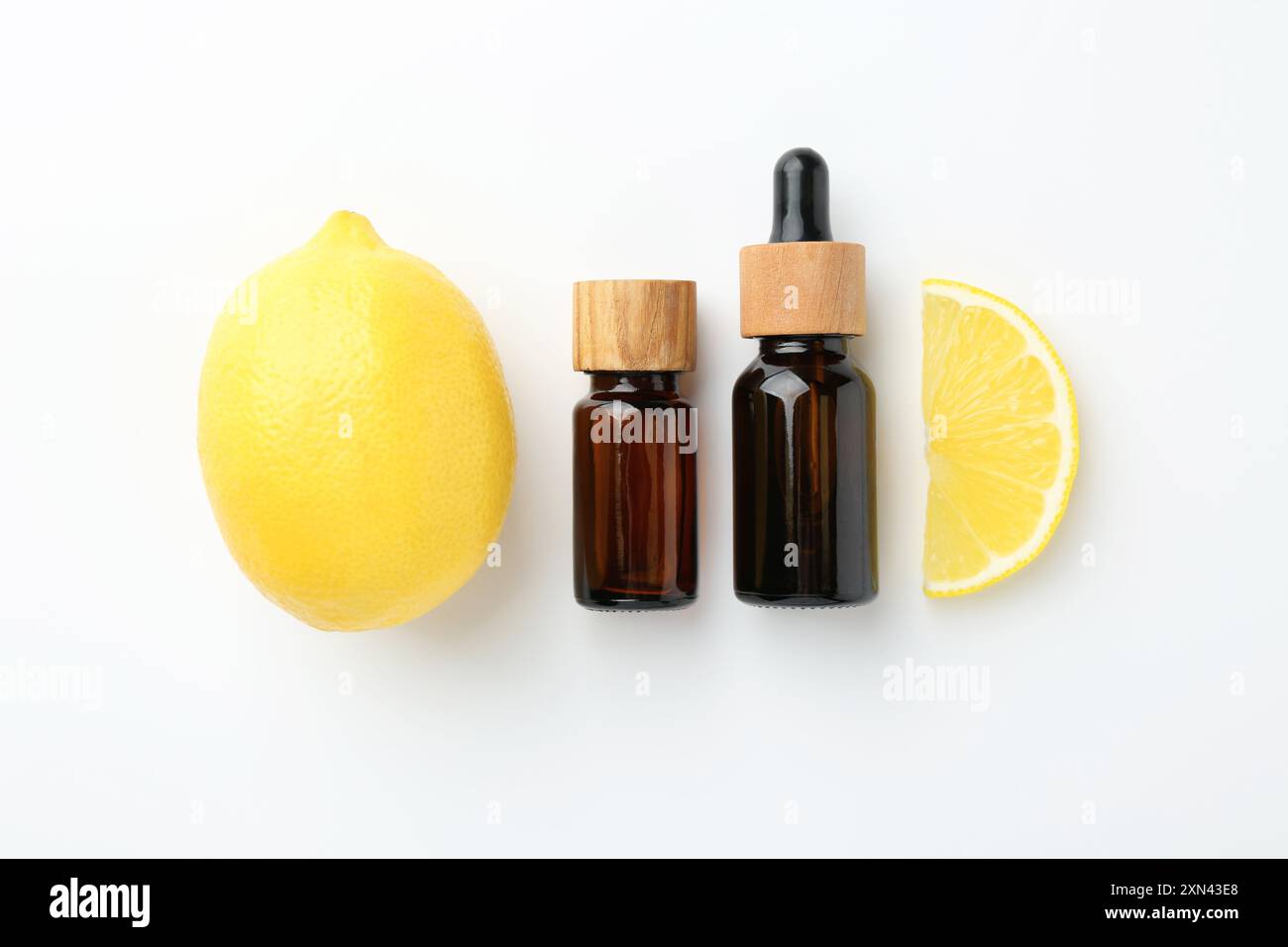 Bottles of essential oils and lemon on white background, top view Stock ...
