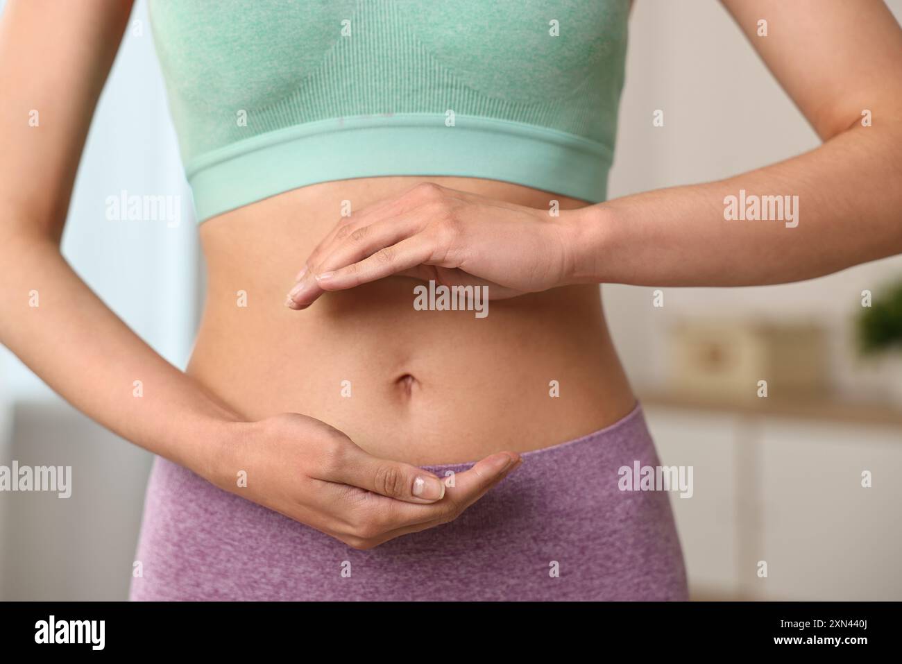 Healthy digestion. Woman holding something near her belly indoors ...