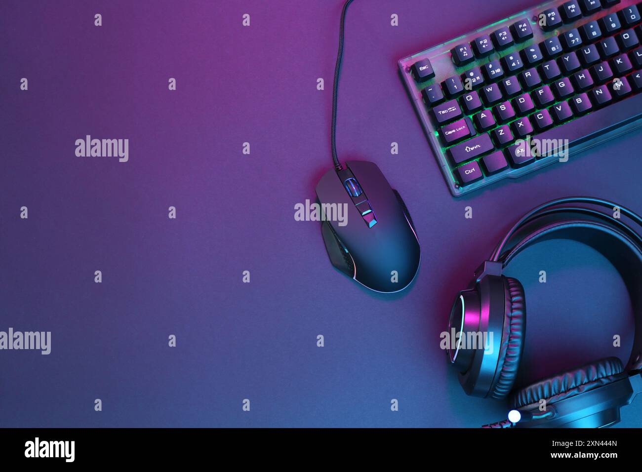 Computer mouse, RGB keyboard and headset in neon lights on dark ...