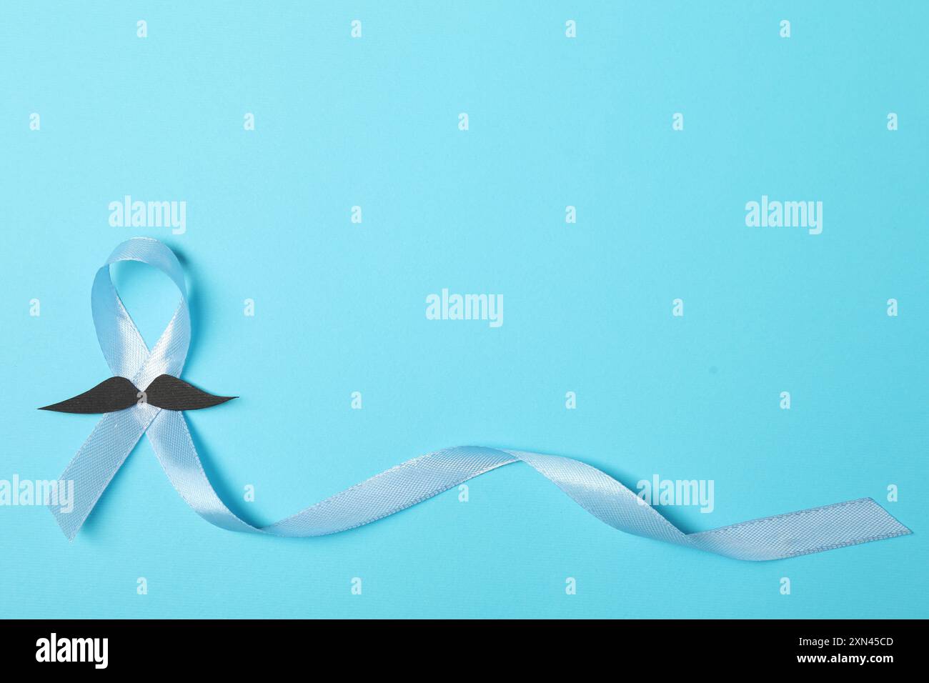 Light blue ribbon and fake mustache on color background, top view with ...