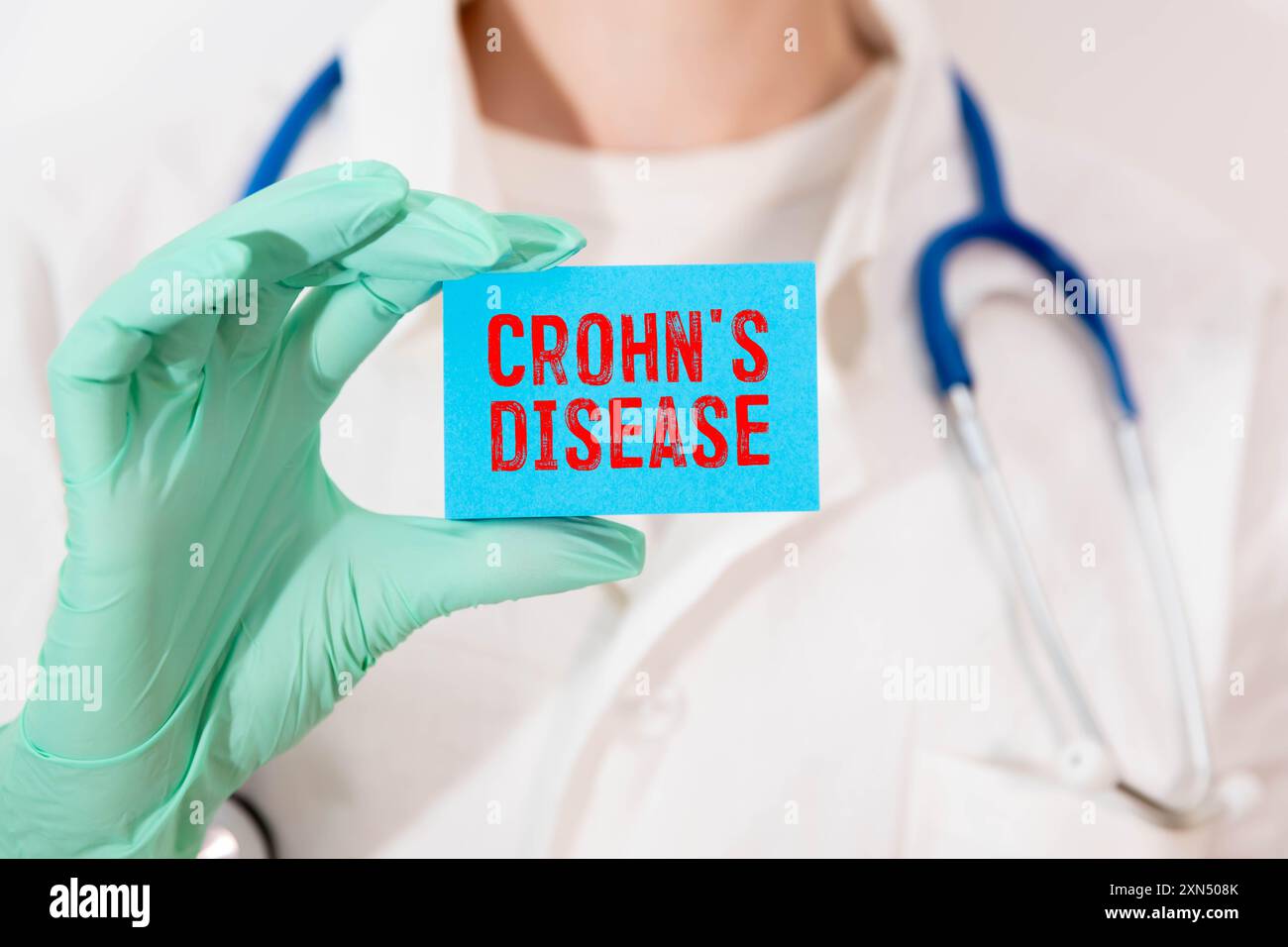 Doctor holding a card with diagnosis words Crohn's disease. Healthcare ...