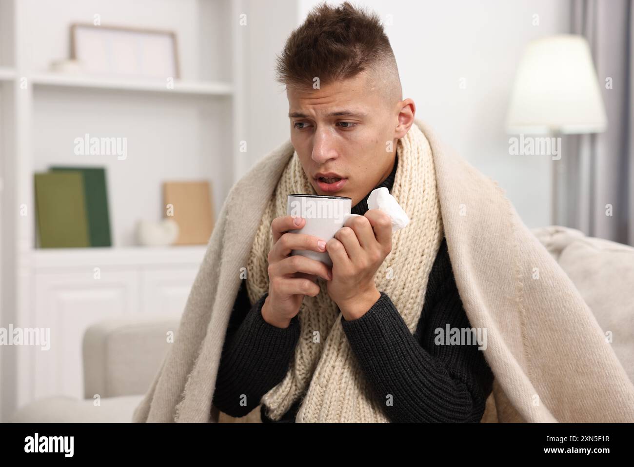 Cold symptom. Young man suffering from fever at home Stock Photo - Alamy