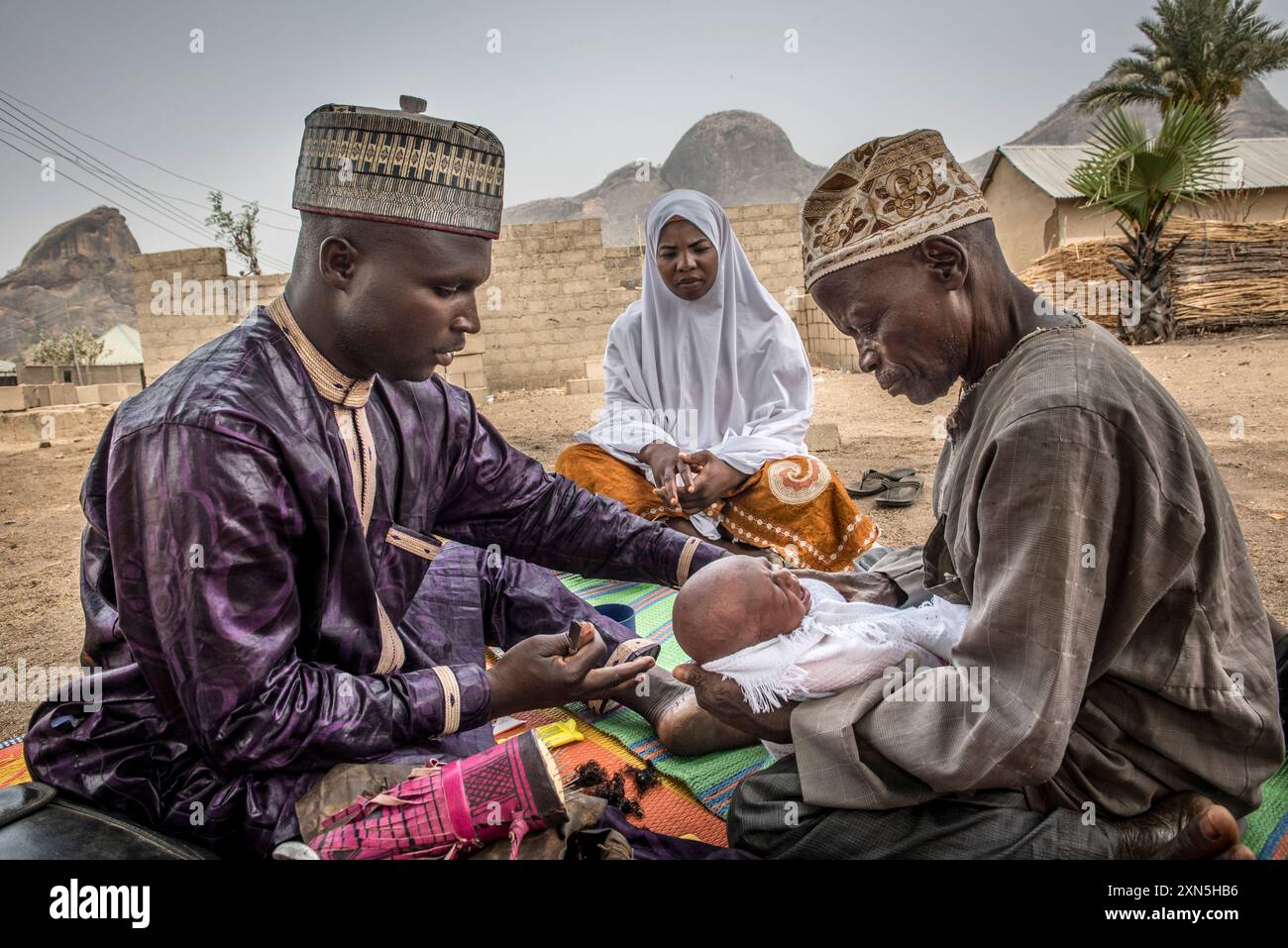 Barber shaving a seven day old baby's head. Photographed in Wandi ...
