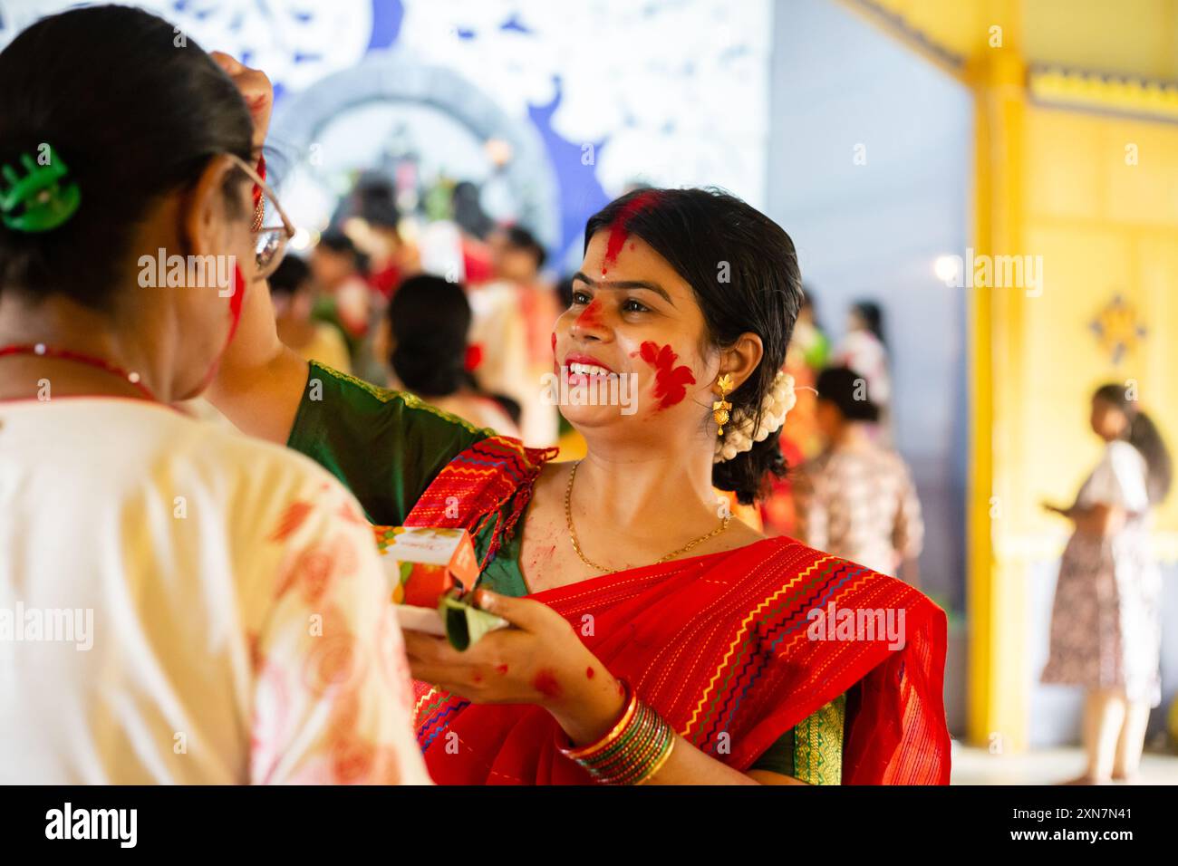A beautiful woman in traditional dress with red colored smiling face ...