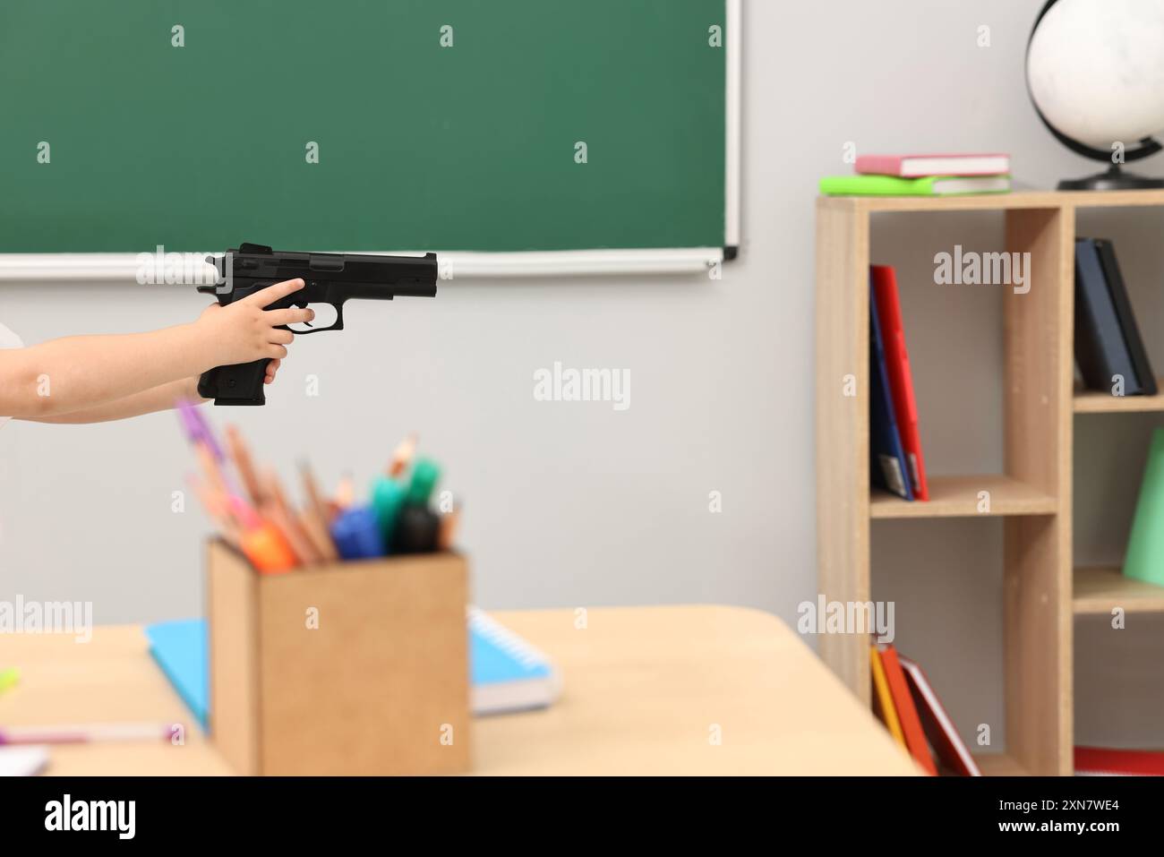 Child with gun in classroom, closeup. School shooting Stock Photo - Alamy