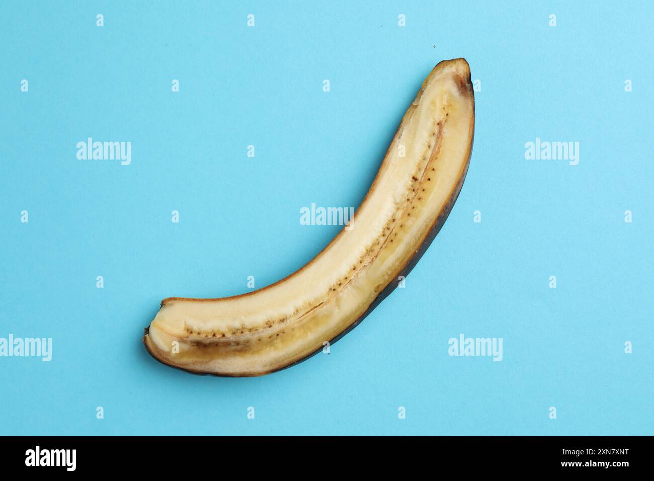 Half of overripe banana on light blue background, top view Stock Photo ...