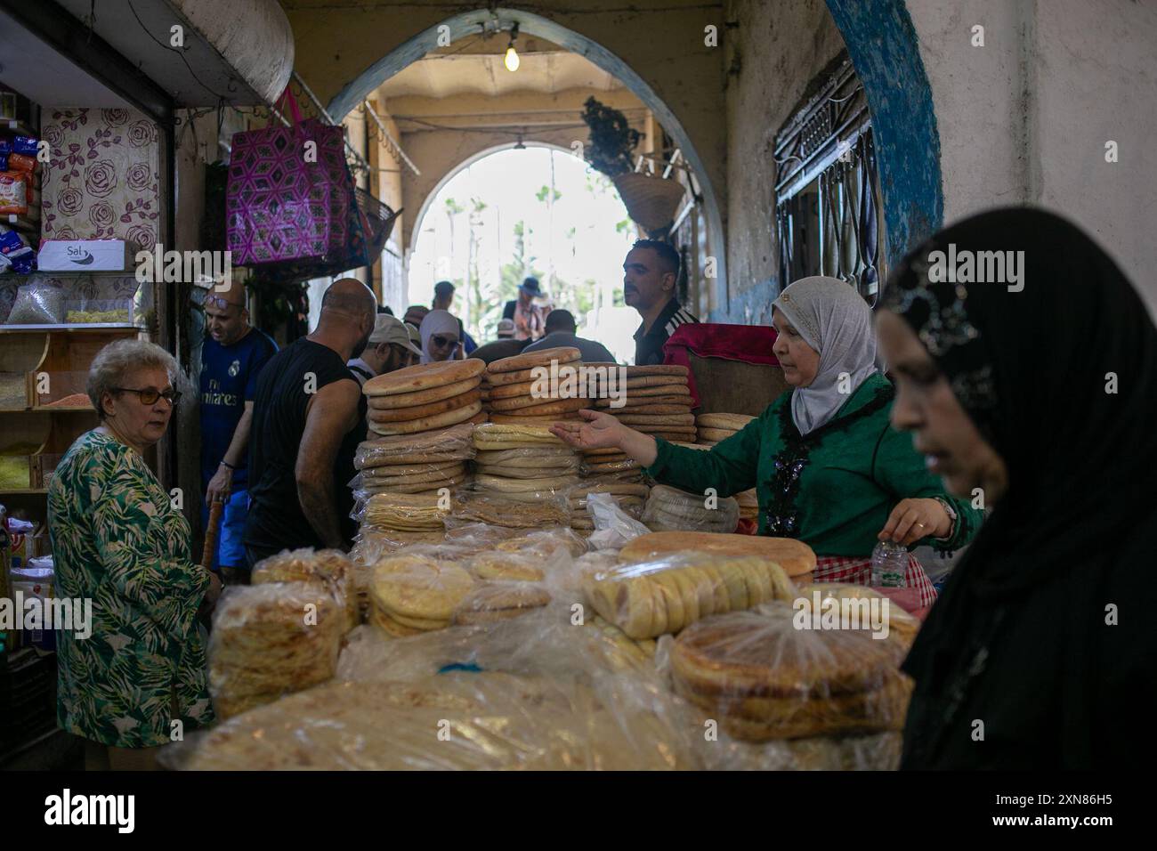 A woman sells bread at one of the market stalls in the Medina in ...