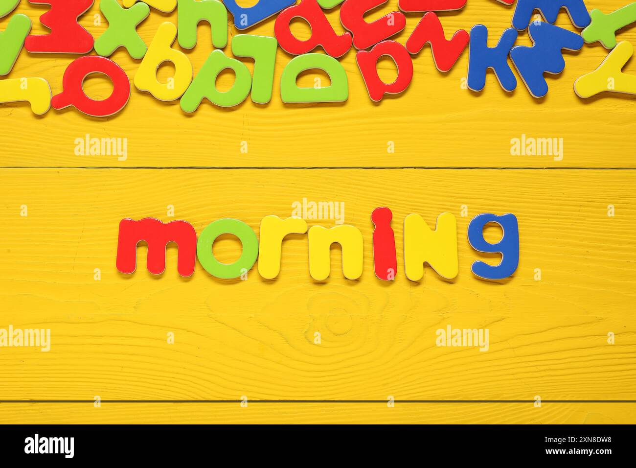 Word Morning made of magnetic letters on yellow wooden background, flat ...