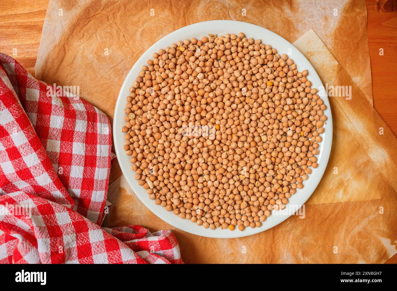 Plate of chickpeas with burned baking paper and red checkered cloth on ...