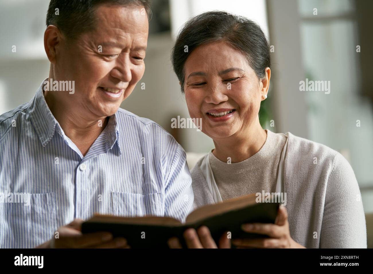 happy senior asian couple sitting on family couch at home reading bible together Stock Photo - Alamy