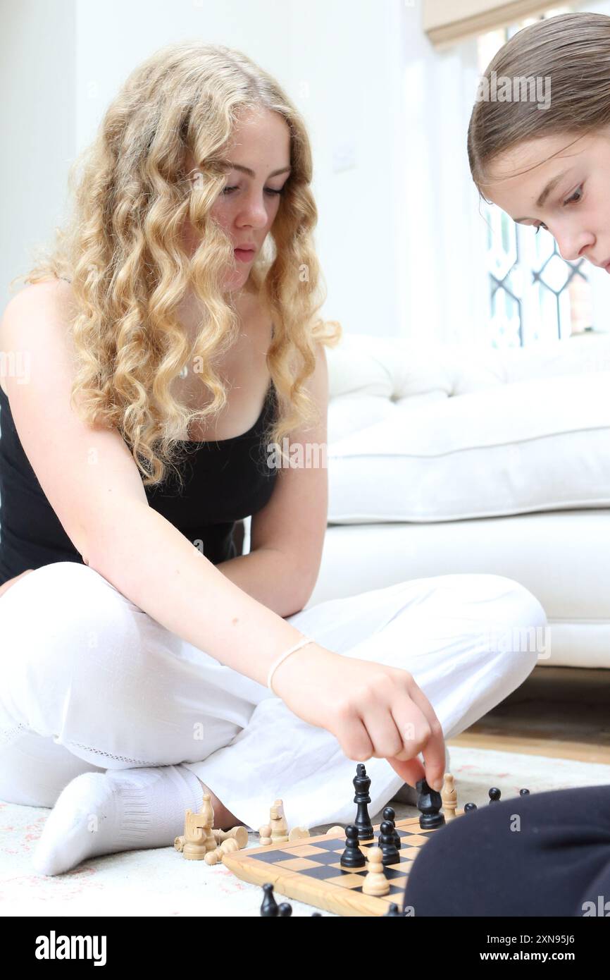 Two girls playing chess sitting on floor - concept thinking skills ...