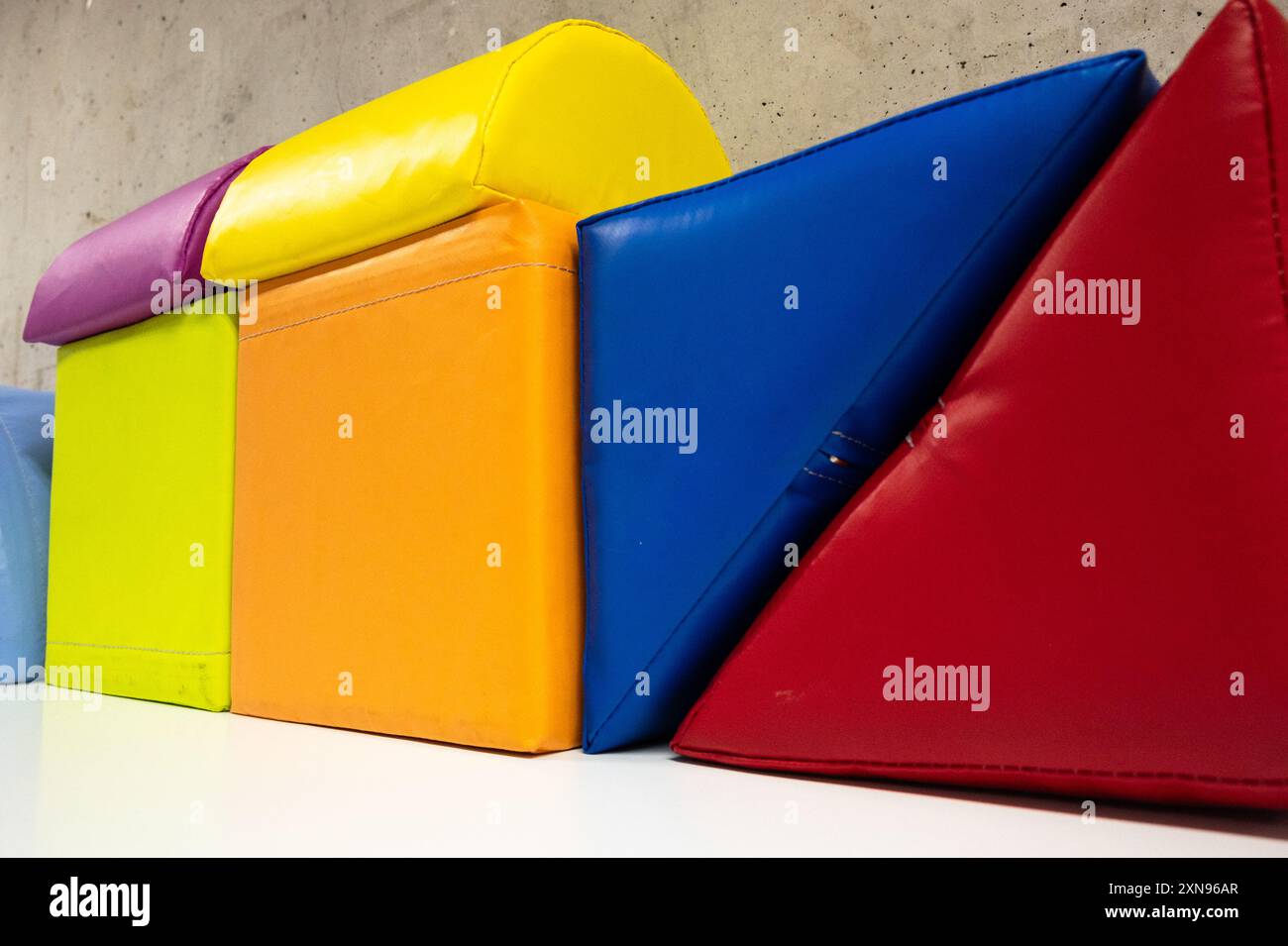 A row of colorful blocks with a red one in the middle. The blocks are ...