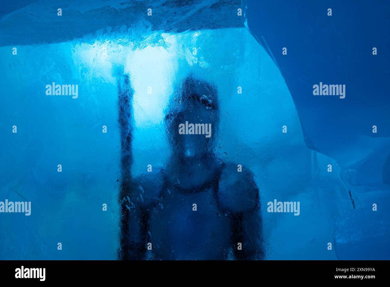 A solitary figure, partially obscured by a frosty, translucent surface ...