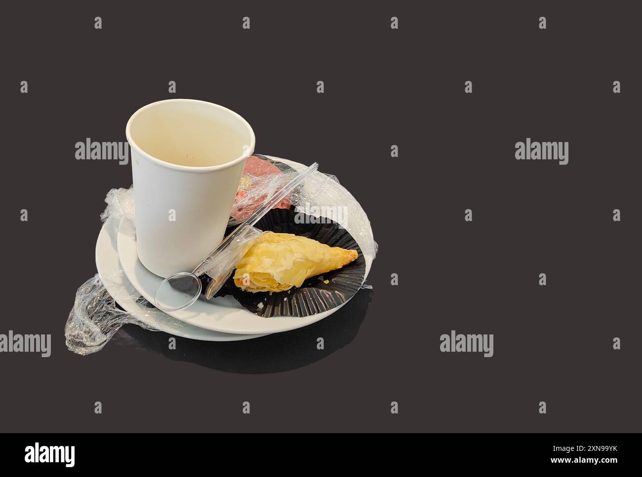 Empty white coffee cup and leftover snack on white plate on black ...