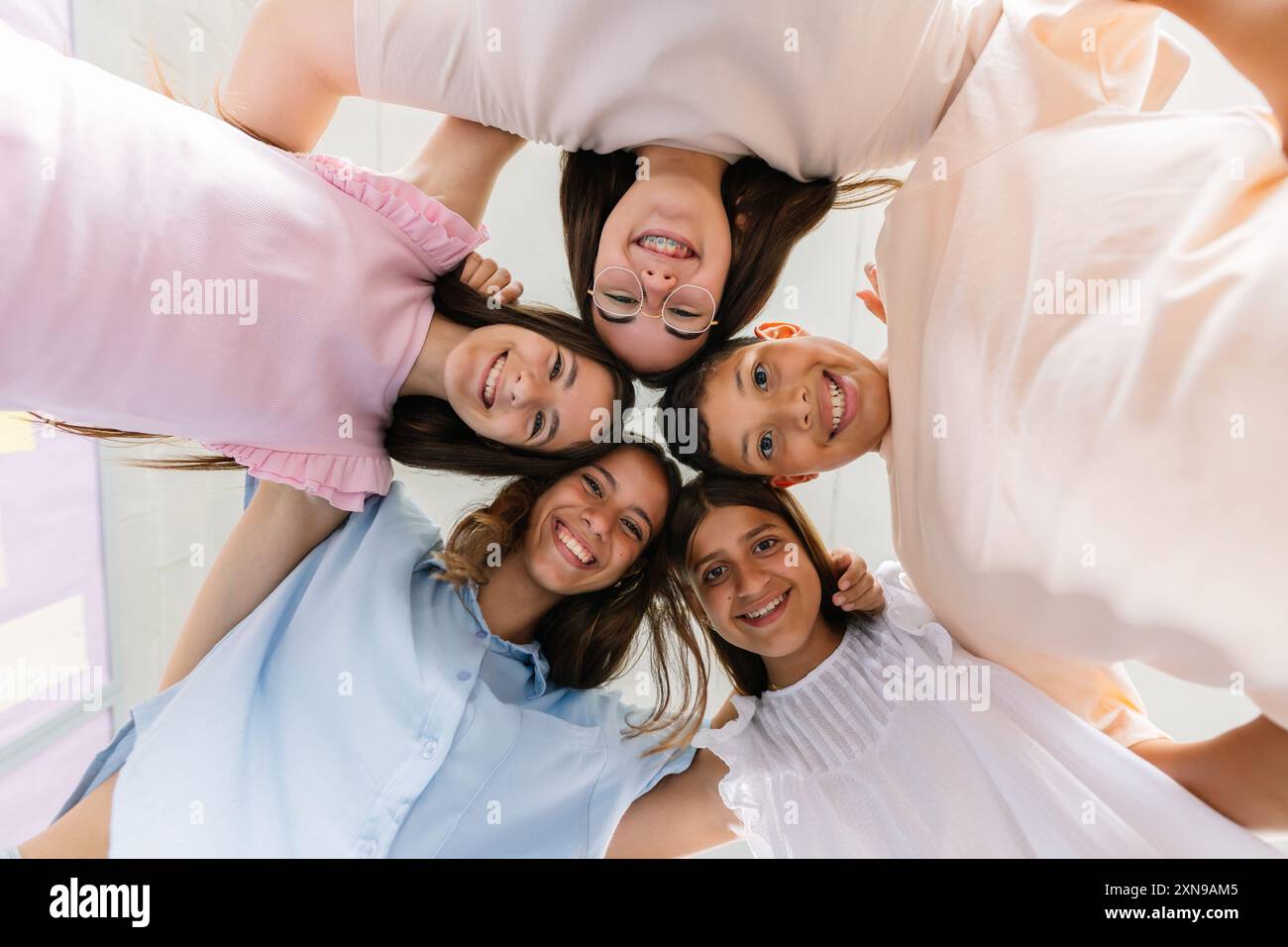 Portrait of smiling school kids standing together in circle at ...