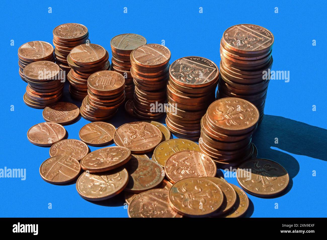British low value coins on an even blue background with 1p, 2p coins ...