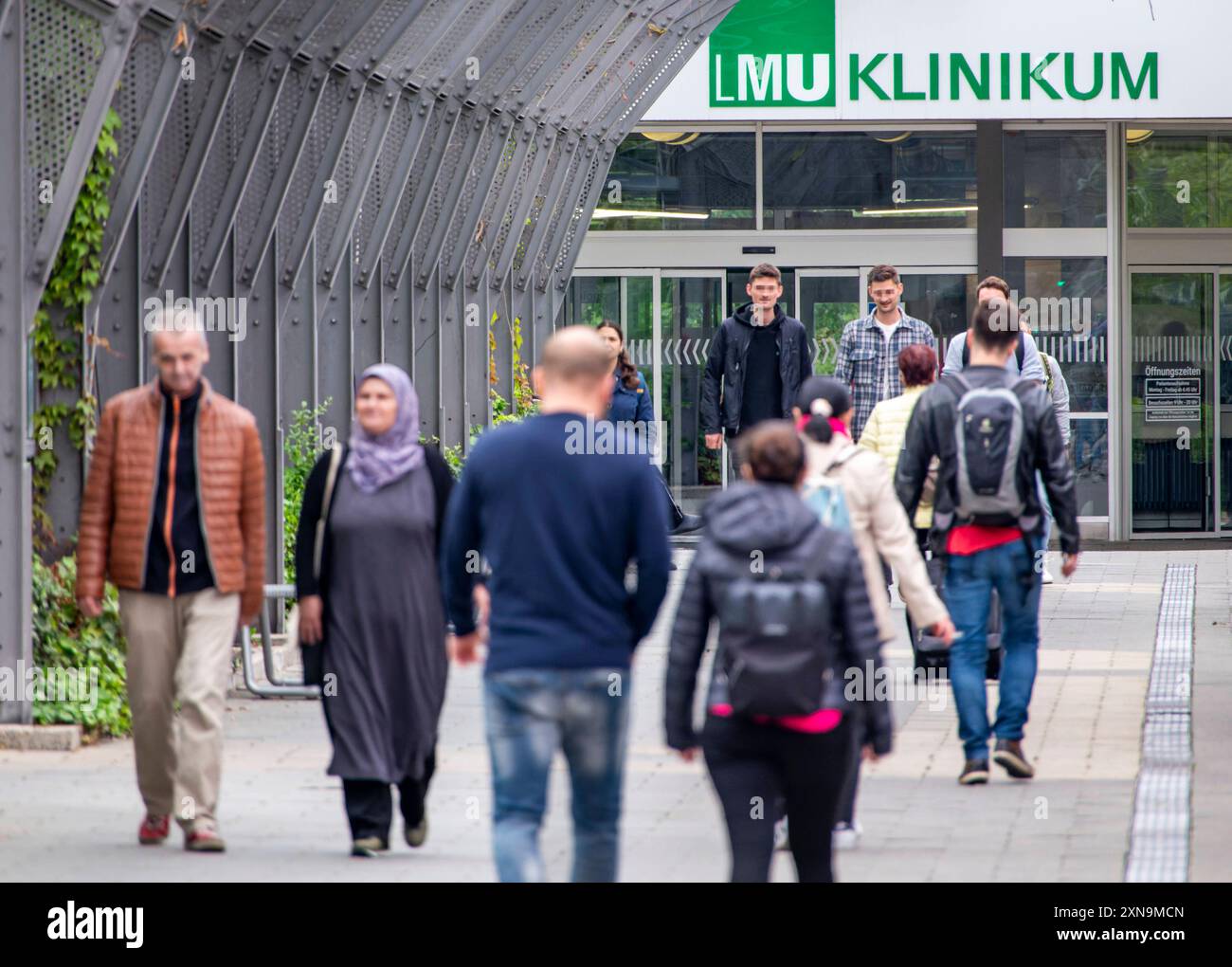 Menschen laufen vor dem Universitaetsklinikum Grosshadern einen Weg ...