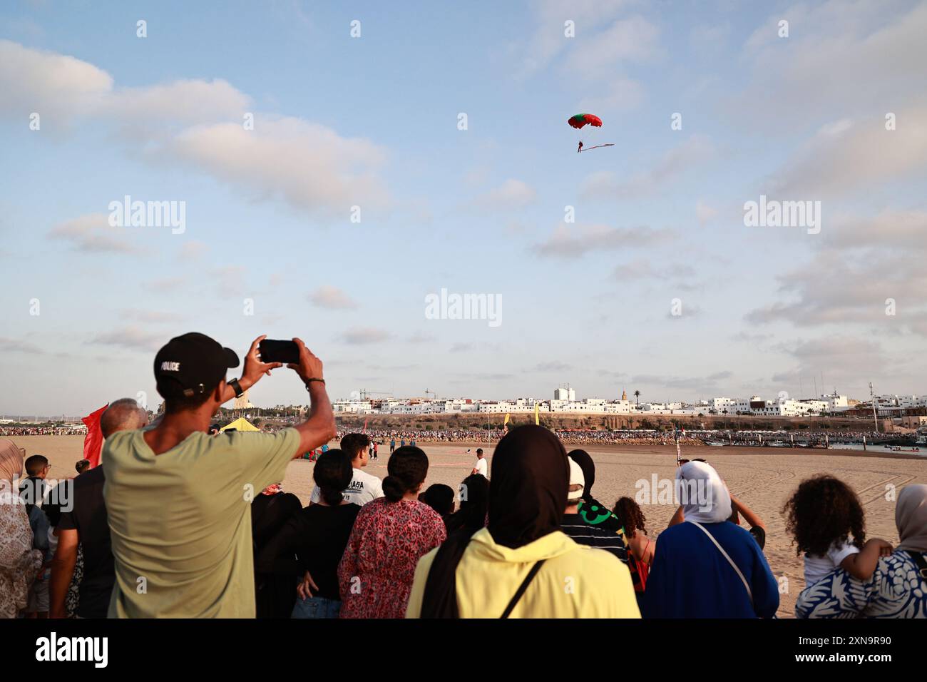 Rabat, Morocco. 30th July, 2024. People watch a parachute jump ...