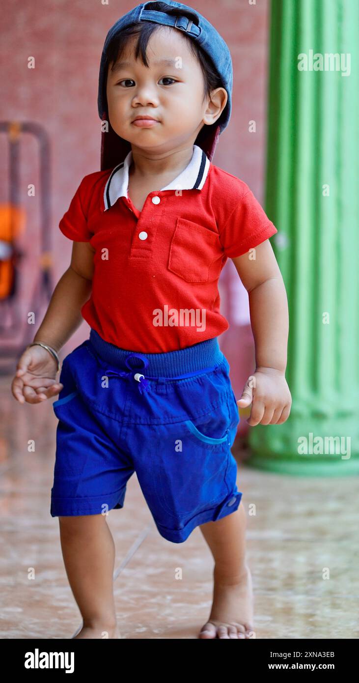 little boy wearing a backwards hat, cute behavior of children exploring ...