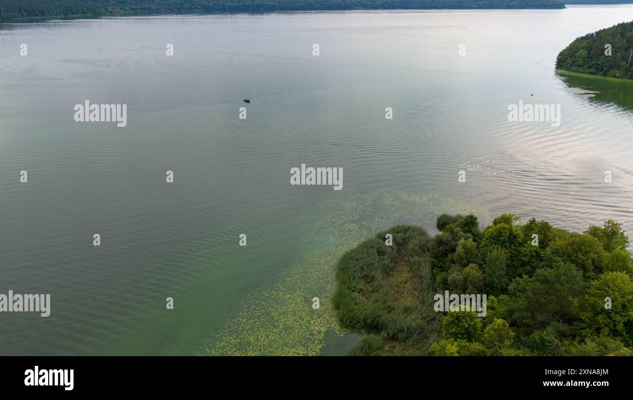 Drone photography of a boat in a lake and people fishing during summer ...