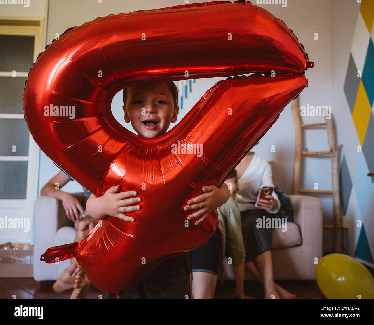 Little boy with big red inflatable number 4 celebrates his birthday ...