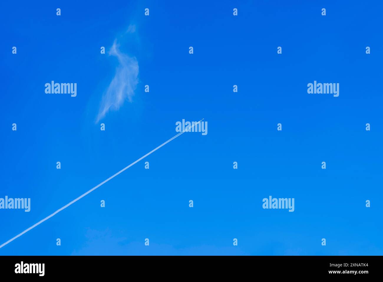 Bright blue sky background with diagonal jet plane trace. Airplane and ...