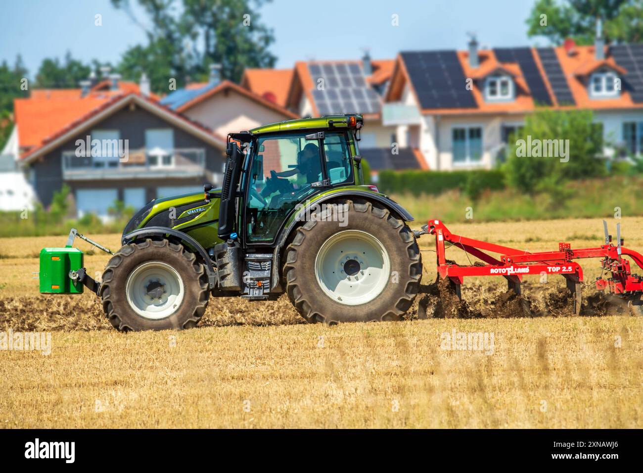 Landwirt bei der Feldarbeit, lockert den Boden mit dem Grubber, Traktor auf dem Acker, Nähe ...