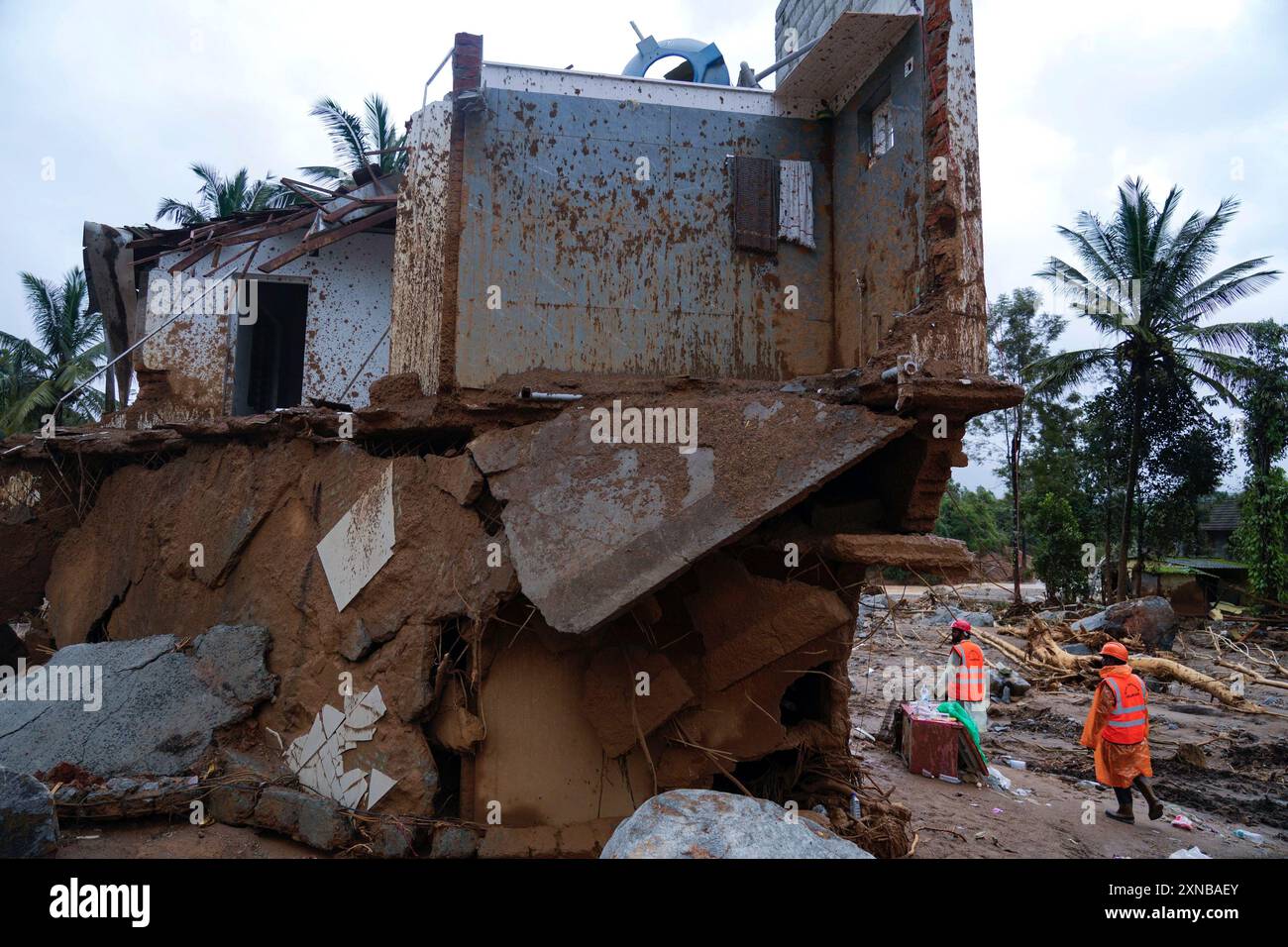 Rescuers walk past a damaged building on their second day of mission ...