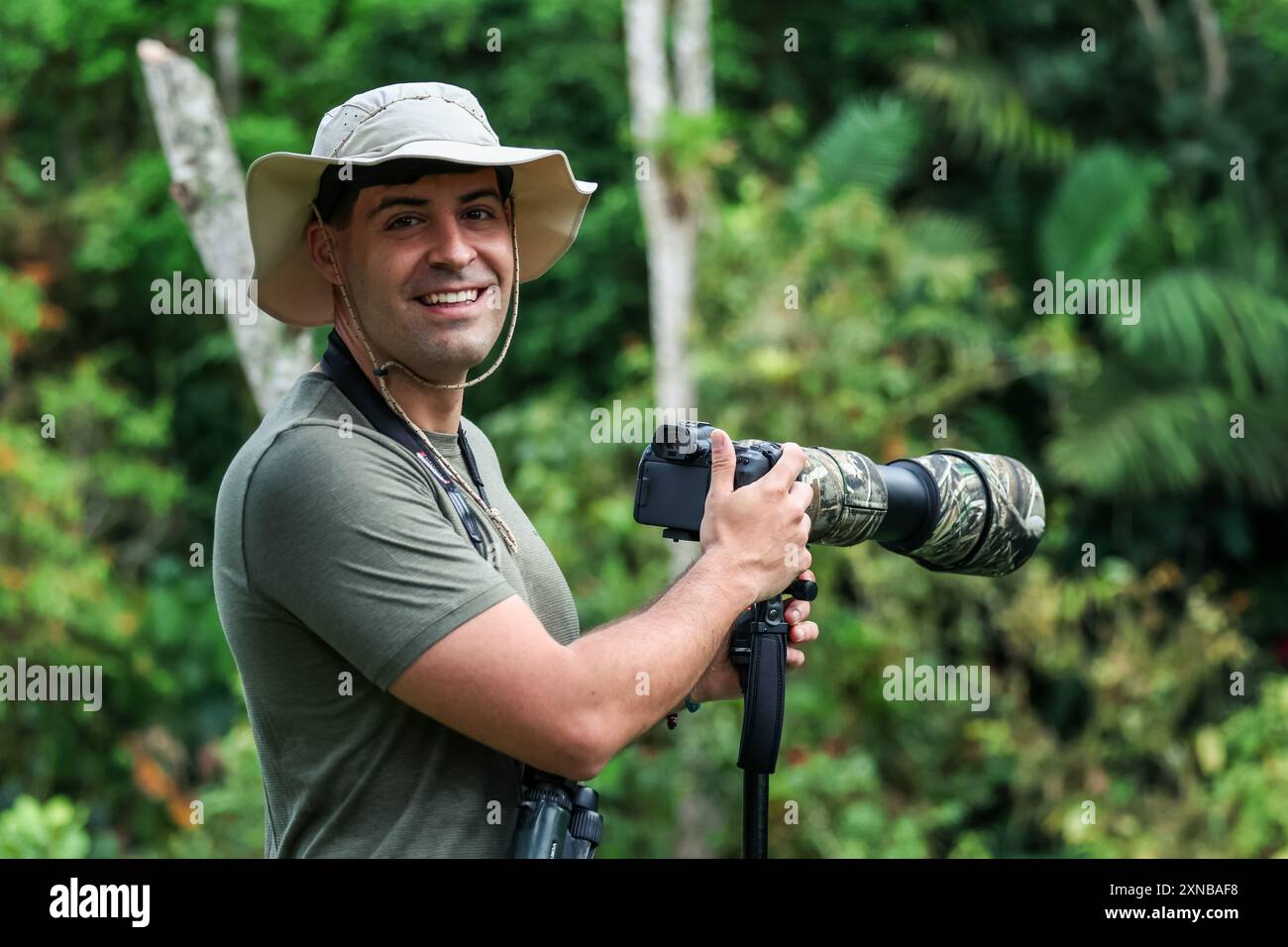 nature photographer with a telephoto lens poses amidst the jungle ...