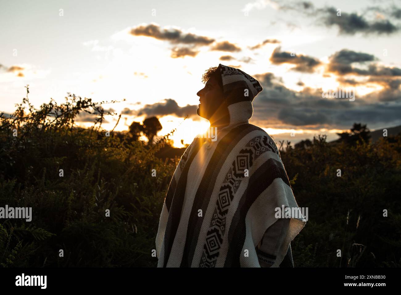 multiracial Latino man wearing a traditional poncho poses against the ...