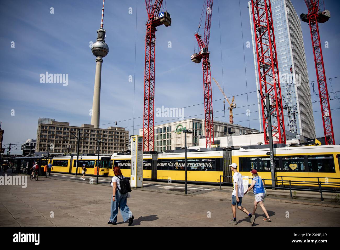 Menschen laufen um einen Tram am Alexanderplatz mit im Hintergrung die Bahnbrücke mit einem ...