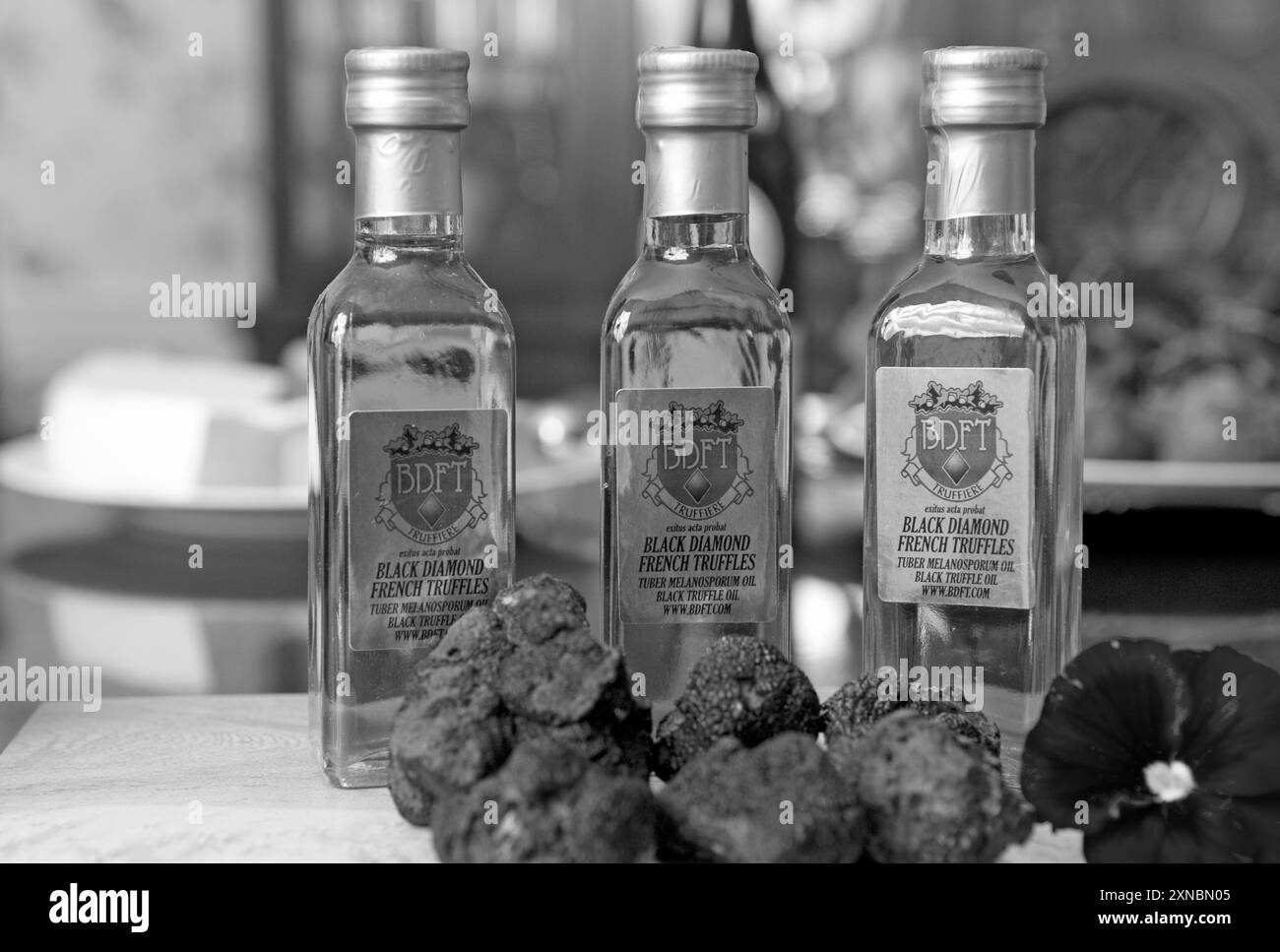 Close-up of fresh black diamond French truffles with three bottles of ...
