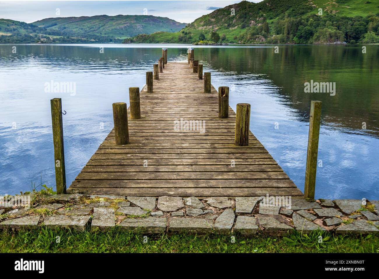 Boat jetty on Ullswater in evening light with still lake Stock Photo ...