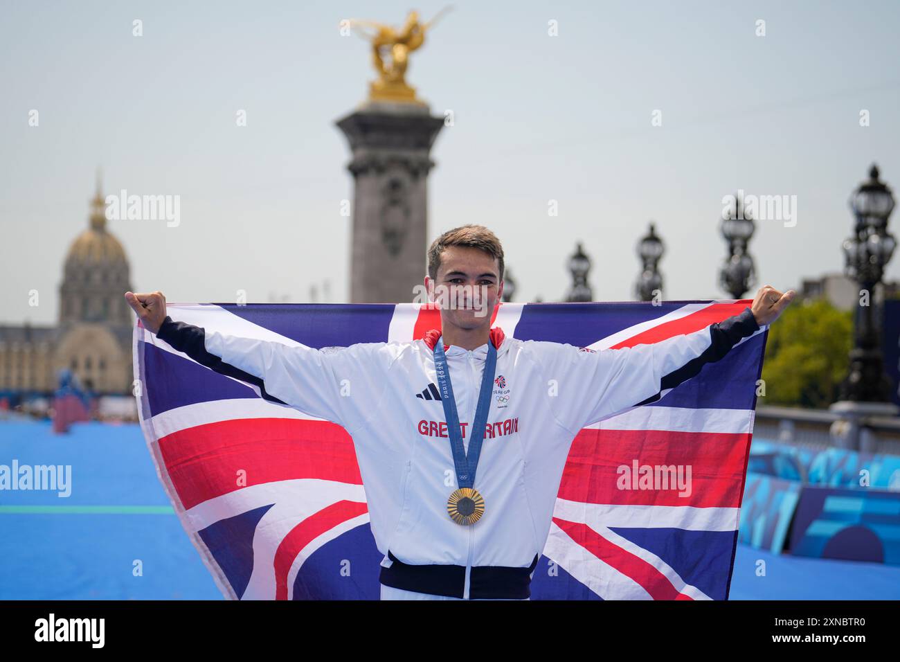 Gold medalist Britain's Alex Yee holds the Union Jack at the end of a ...