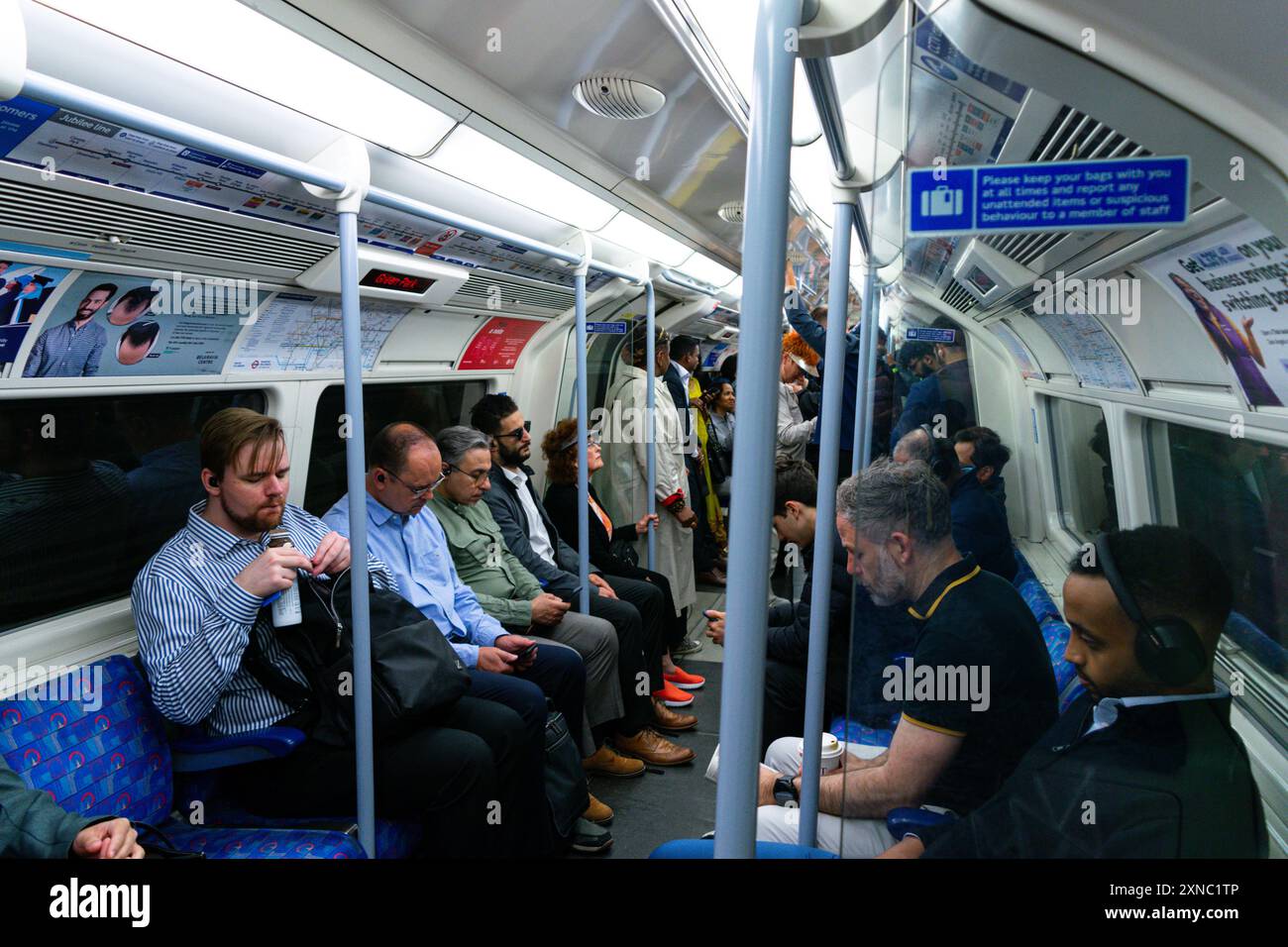 People travelling on a crowded London Underground train carriage ...