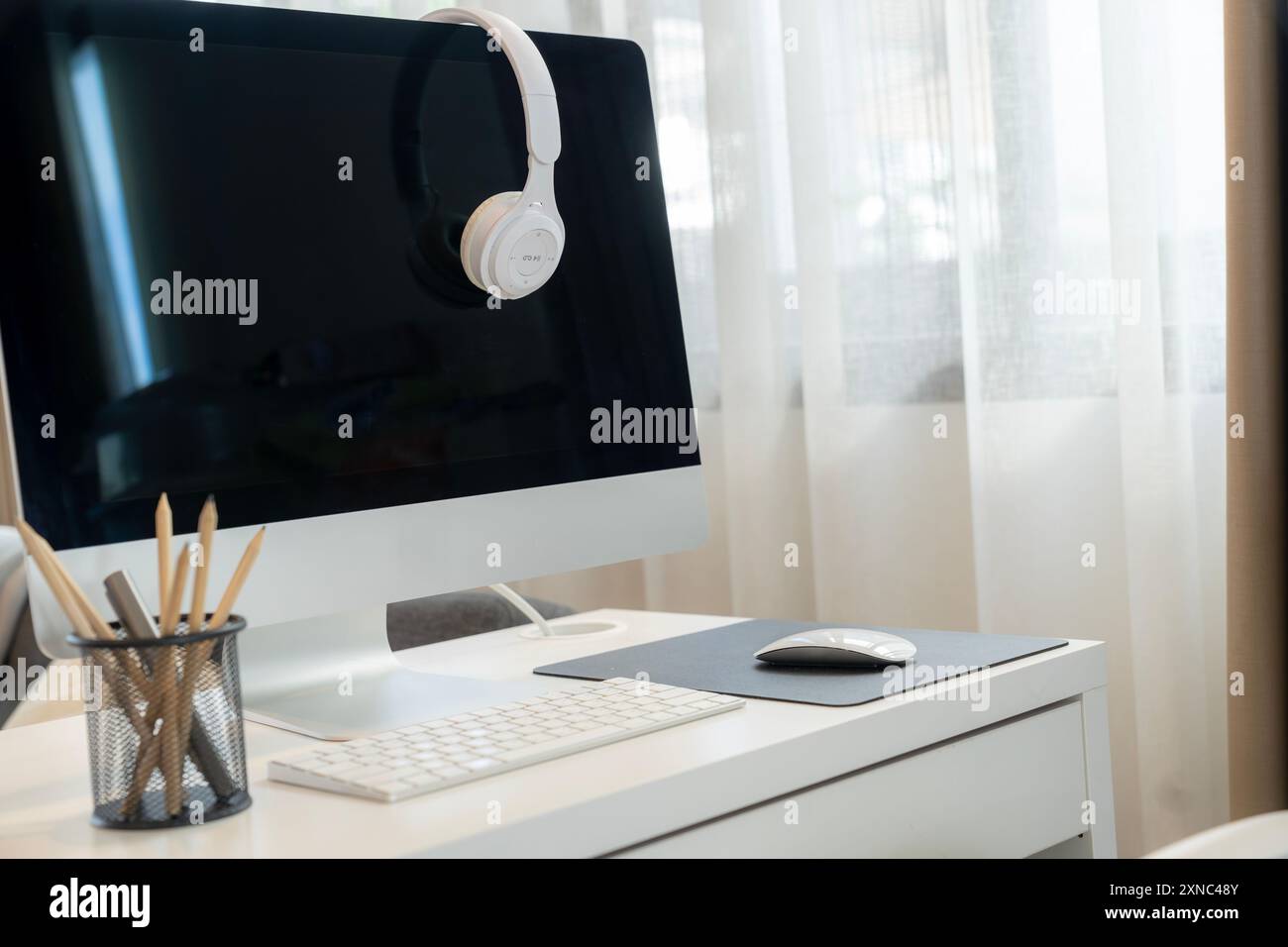 A work desk with Bluetooth headphones placed on it Stock Photo - Alamy