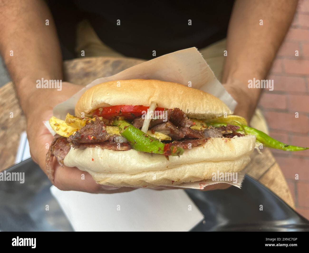 Istanbul, Turkey. 31st July, 2024. A person eats a kebab sandwich in a ...