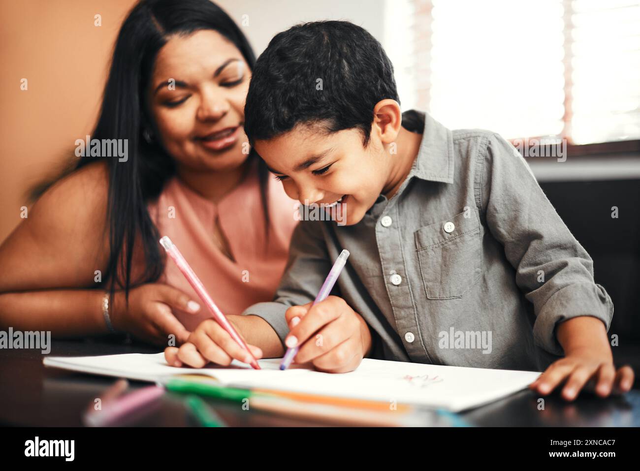 Child, colouring and woman with book in home, creativity activity and ...