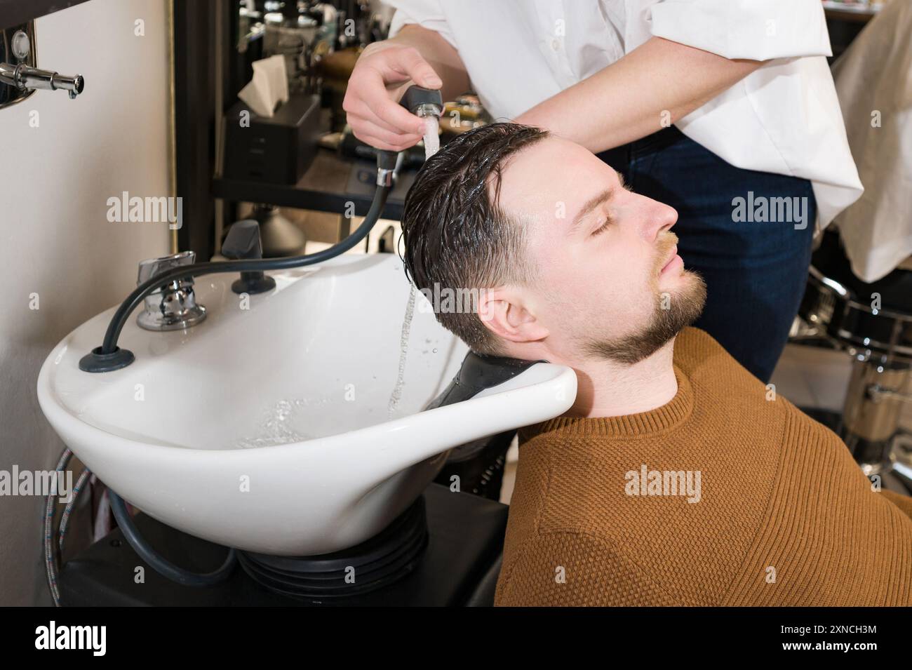 Barber shampooing washing a male client's head in the sink Stock Photo ...