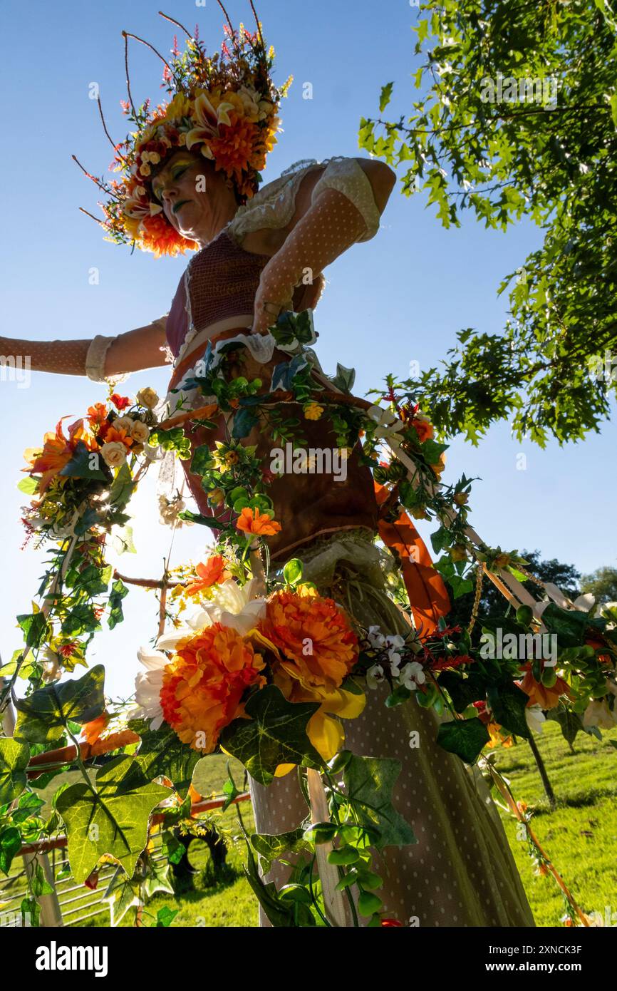 Stilt walkers visit an outdoor tourist location in the summer sunshine ...