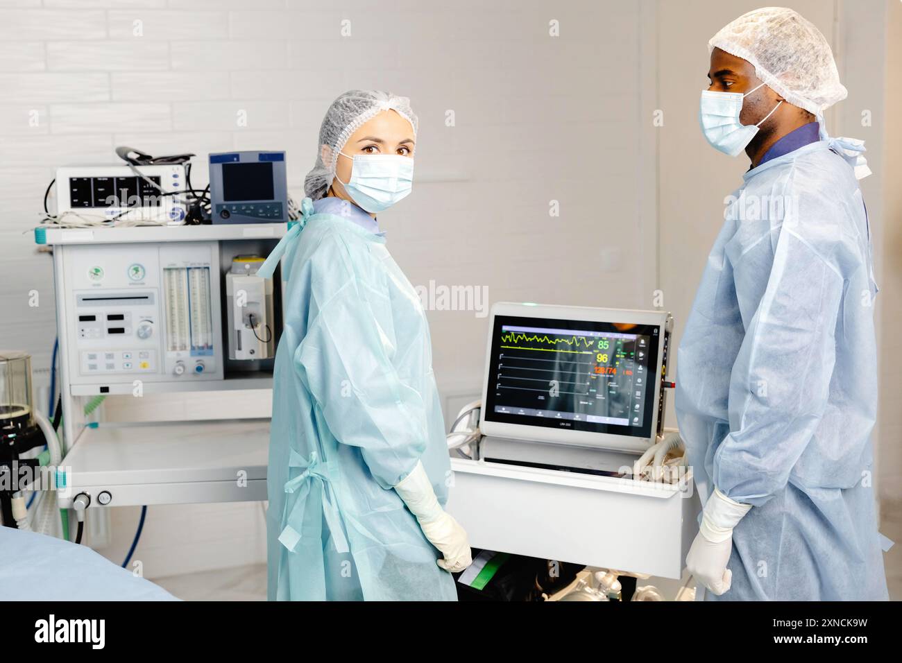Medical professional in gown and mask operating machine Stock Photo - Alamy
