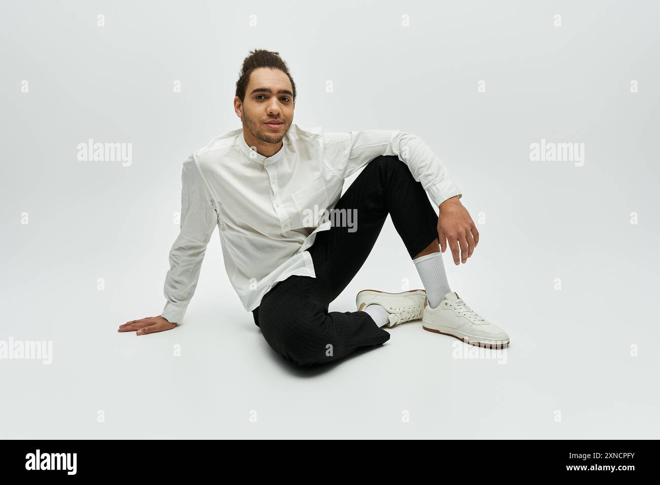A stylish African American male model poses in a white shirt and black ...