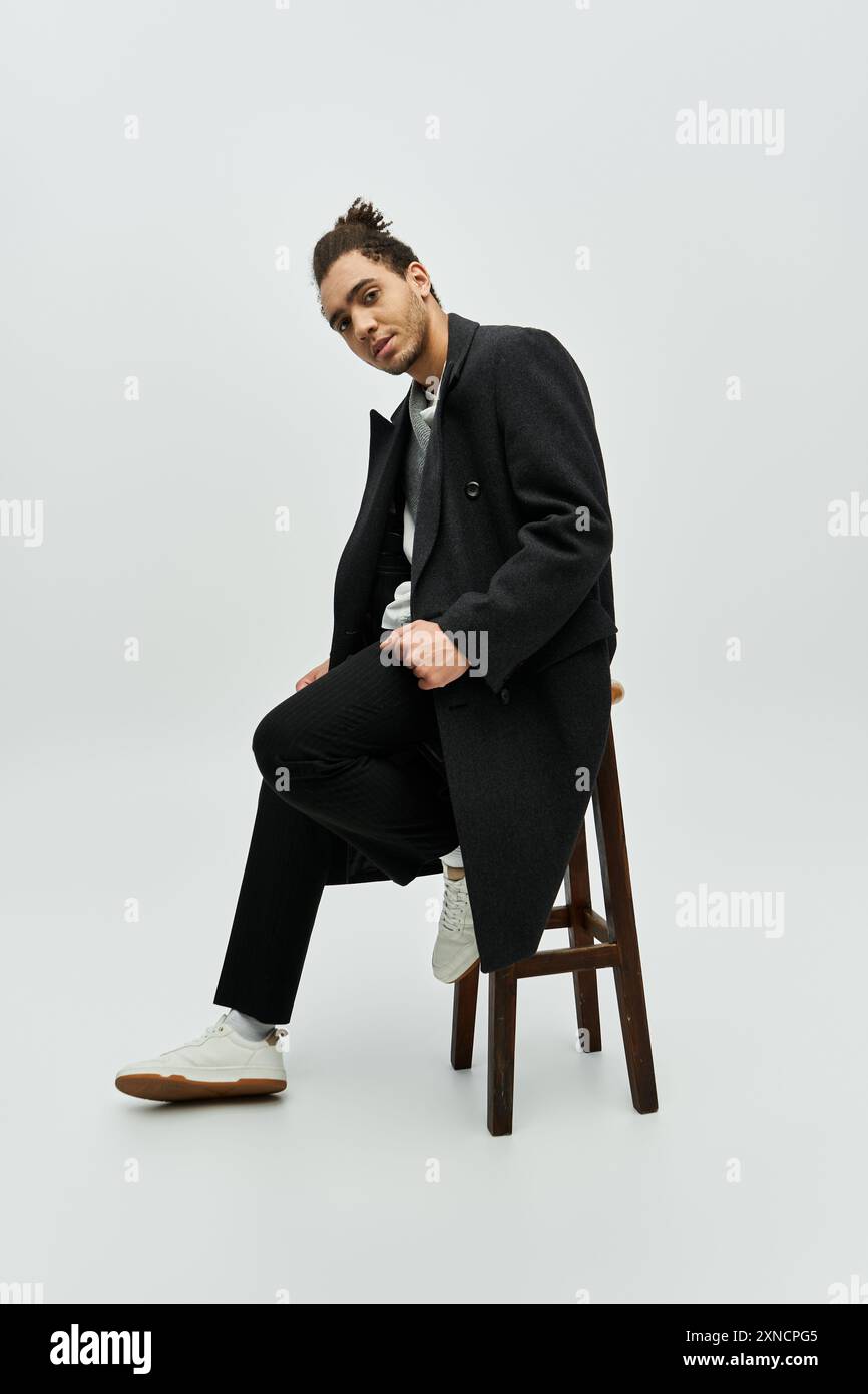 An African American male model poses in a stylish black coat against a ...