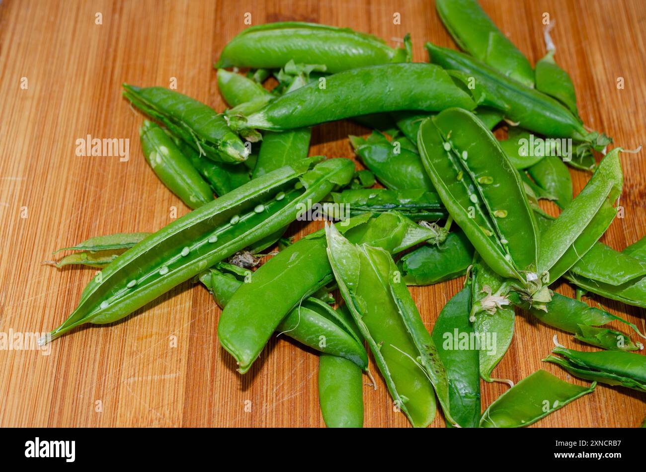 Empty pea pods on a wooden background Stock Photo - Alamy