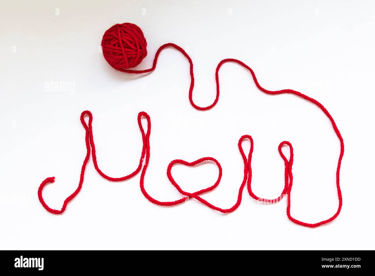 The red ball of wool and red thread written word MOM with heart ...