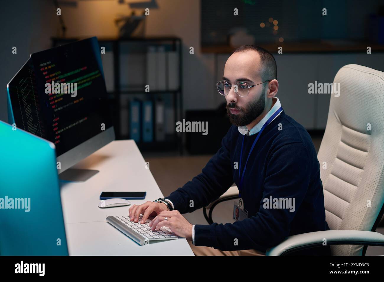 High angle portrait of bearded adult man using computer while coding ...